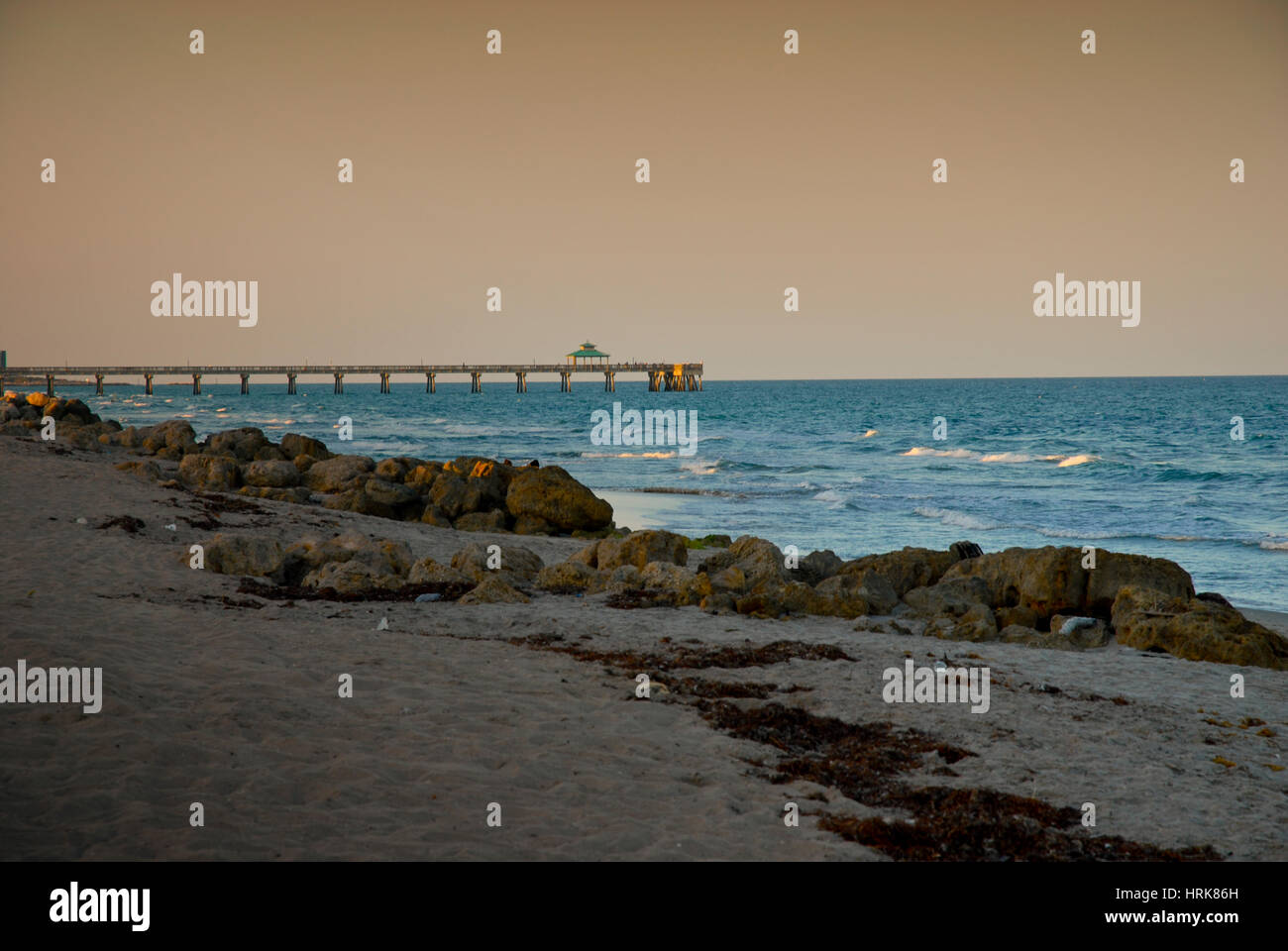 beach with pier rocks and waves Stock Photo - Alamy