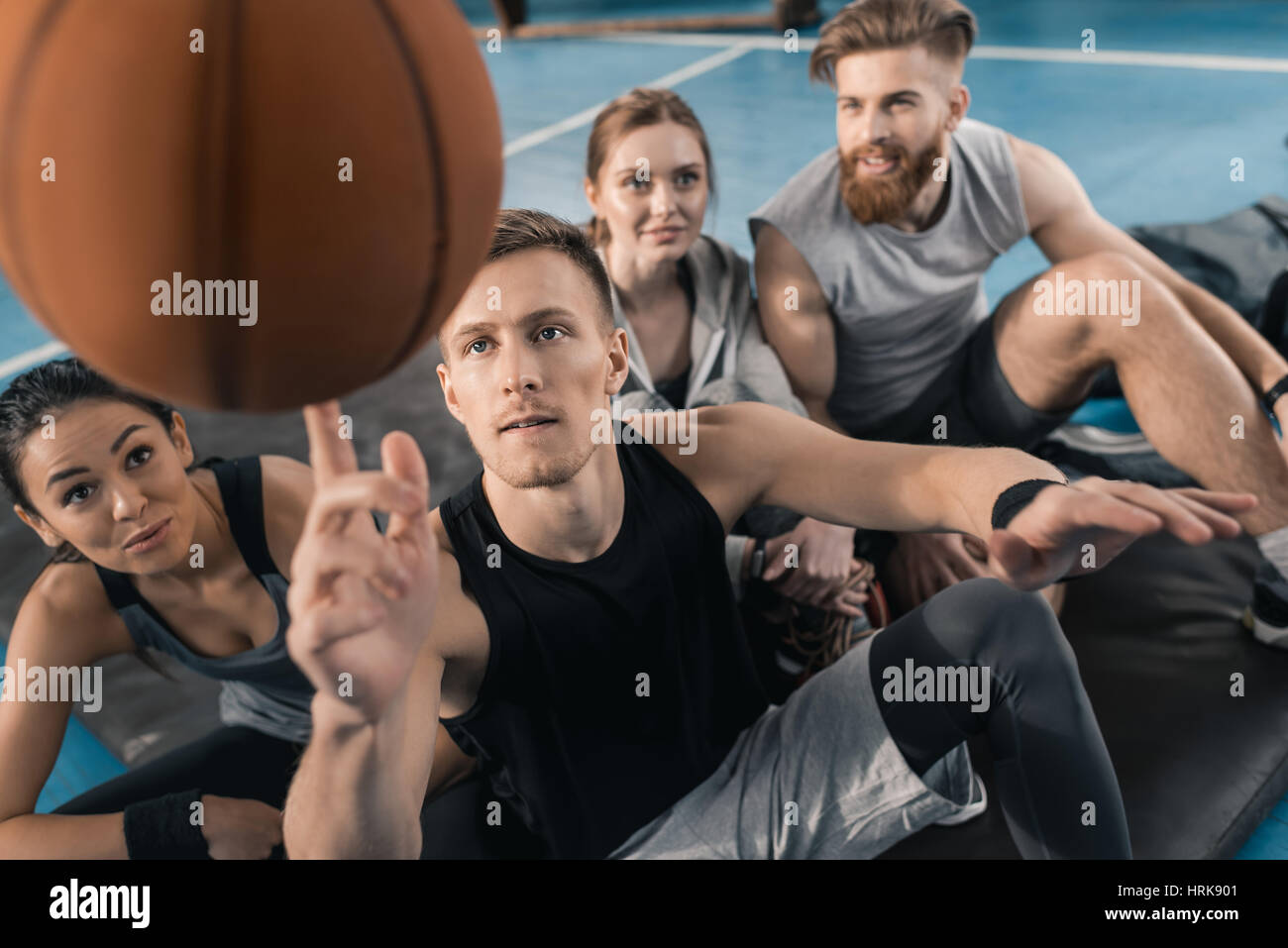 Sporty young people looking at man balancing ball on finger Stock Photo ...
