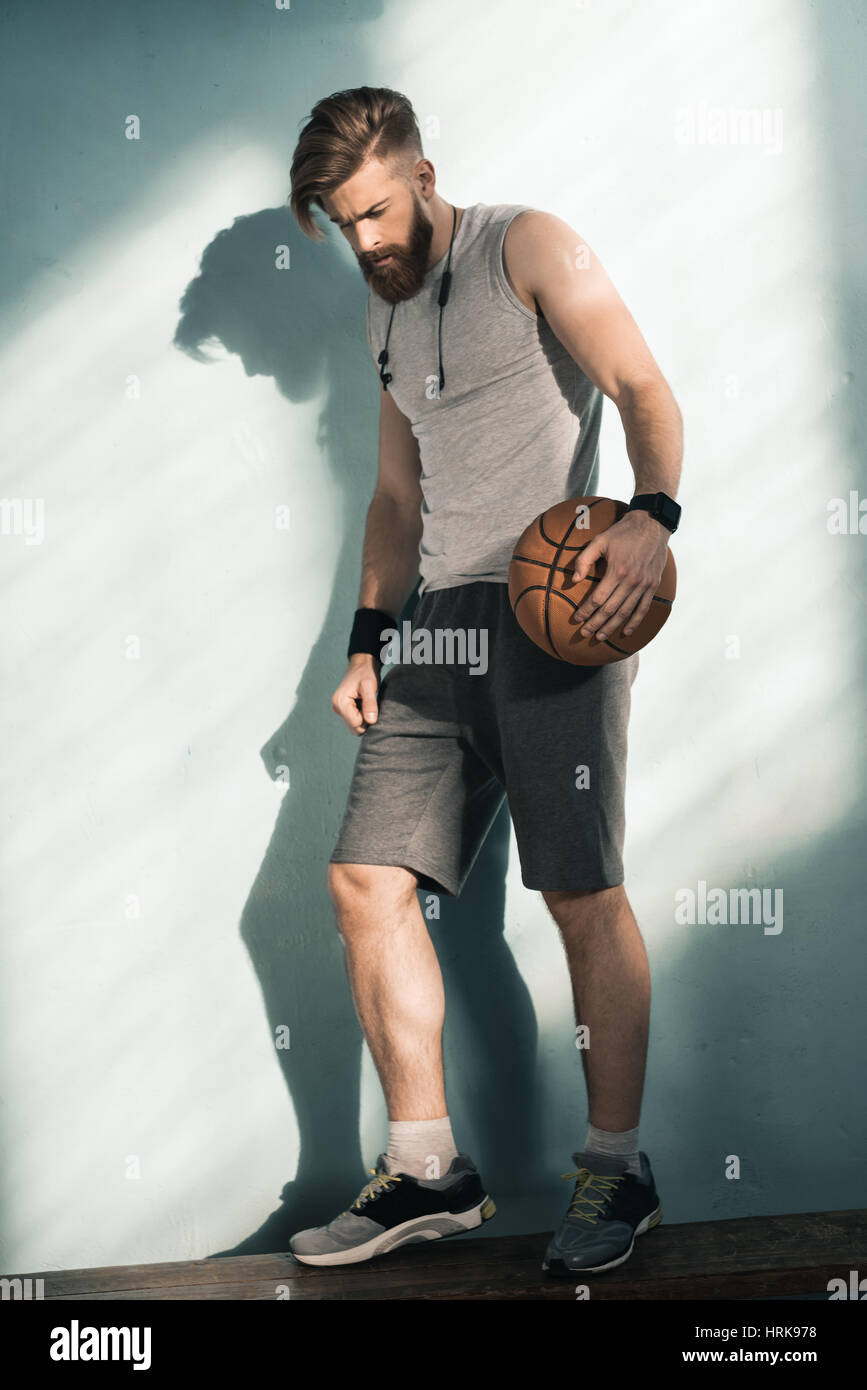 side view of pensive sporty man holding basketball ball in hands Stock ...