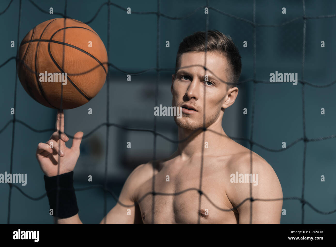 sporty man holding basketball ball on finger Stock Photo - Alamy