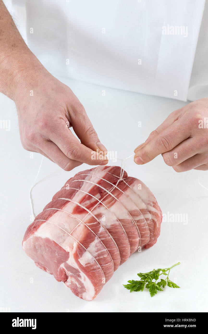 Raw rolled meat enclosed in tied netting. composition Stock Photo - Alamy
