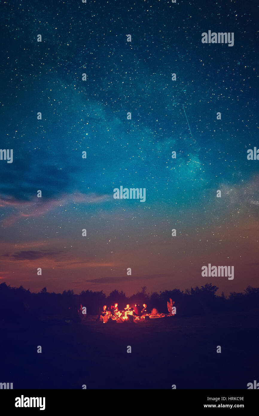 Camping fire under the amazing blue starry sky with a lot of shining ...