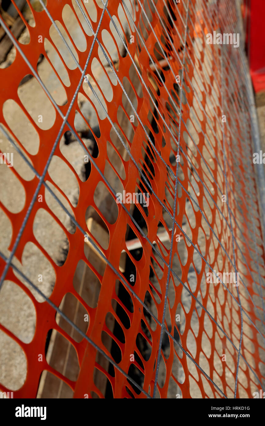 orange safety net to delimit the area of a road construction site in ...