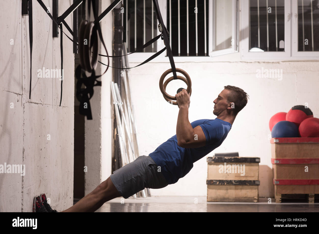 Fitness handsome man doing dipping exercise using rings in the gym ...