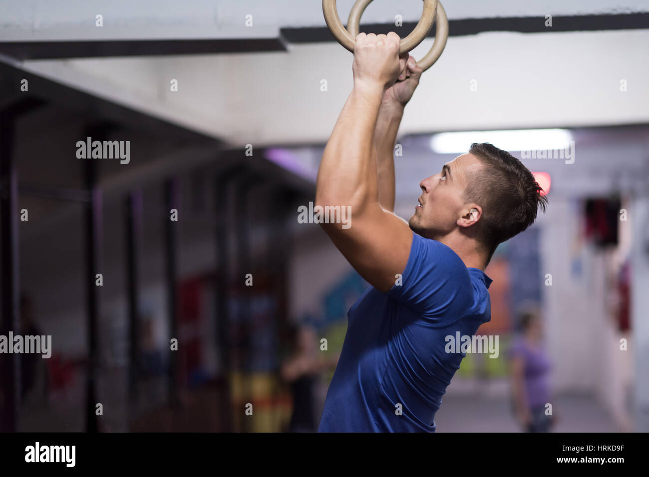 Fitness handsome man doing dipping exercise using rings in the gym ...