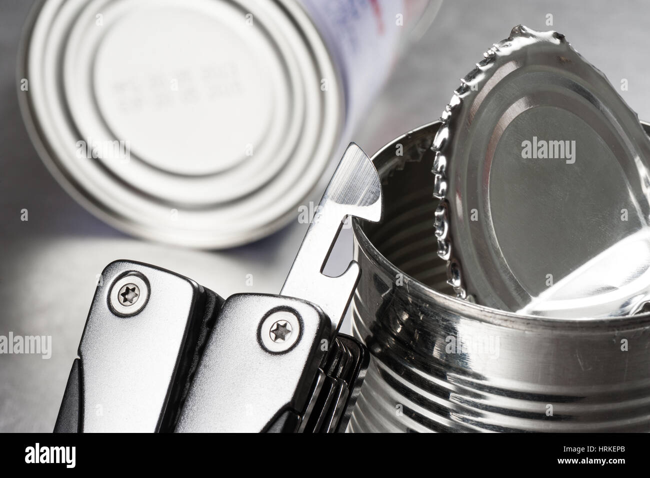 opening the tin with tin opener (can opener Stock Photo - Alamy