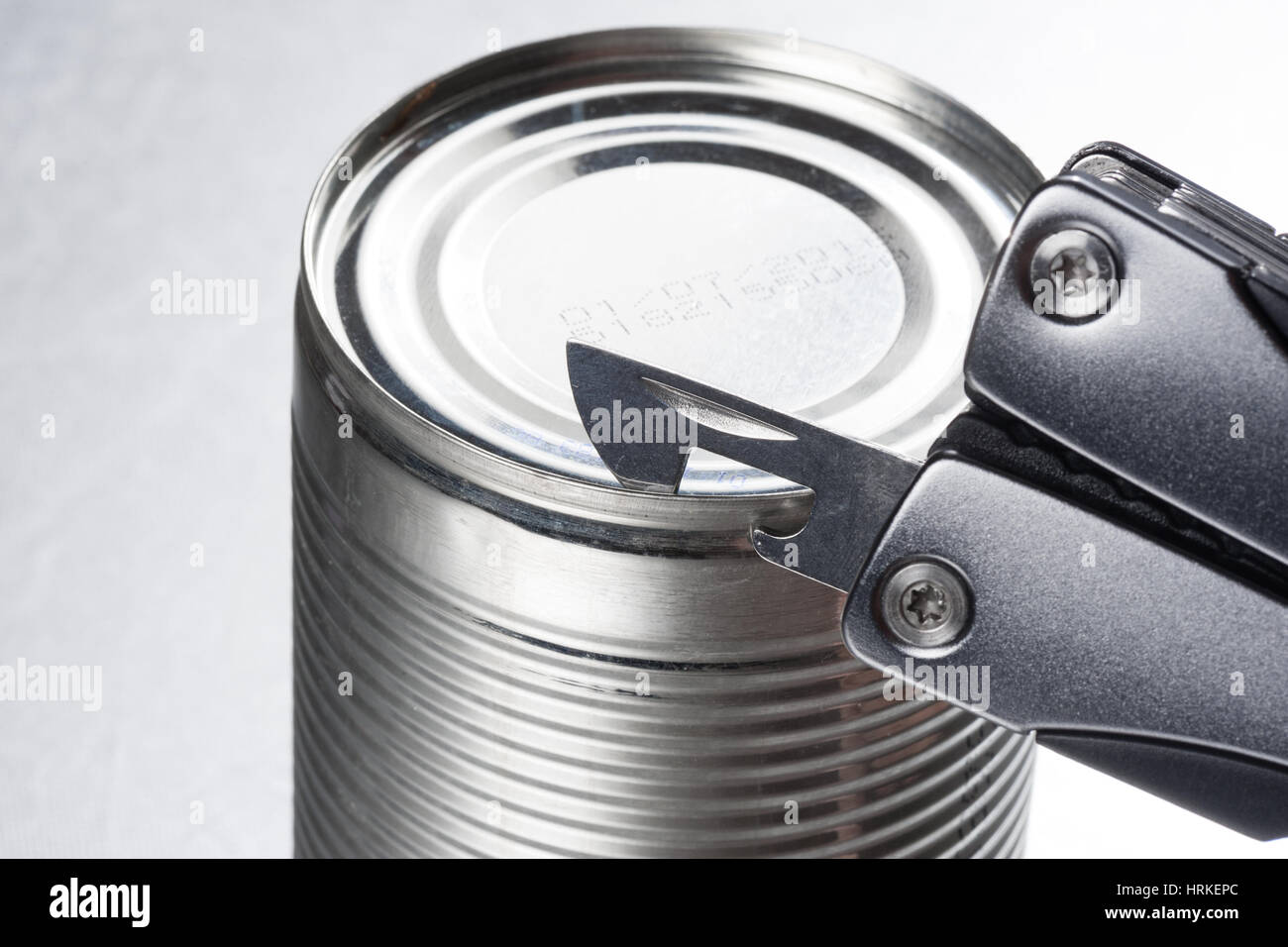 opening the tin with tin opener (can opener Stock Photo - Alamy