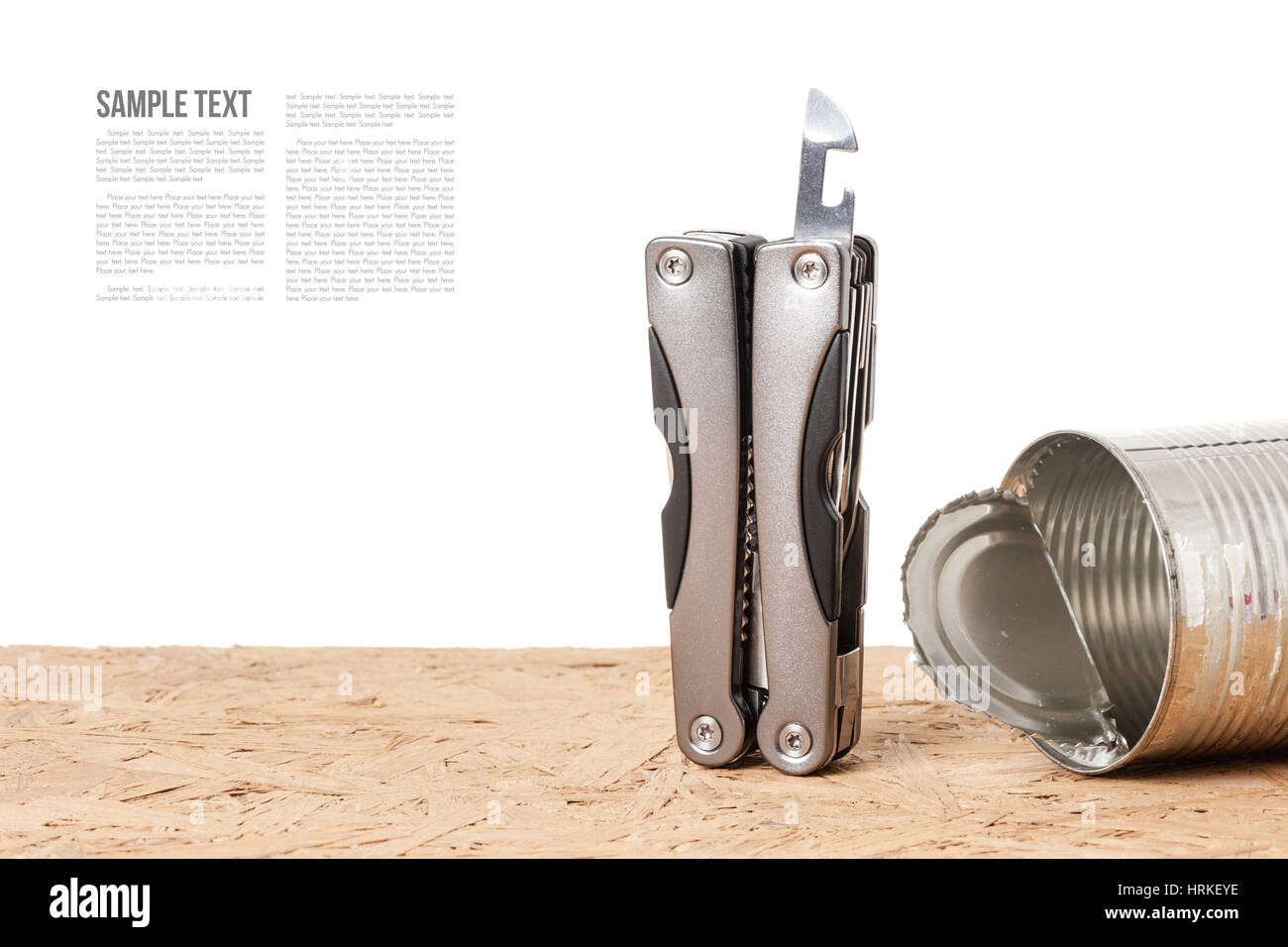 tin opener and opened tin on wooden desk Stock Photo - Alamy