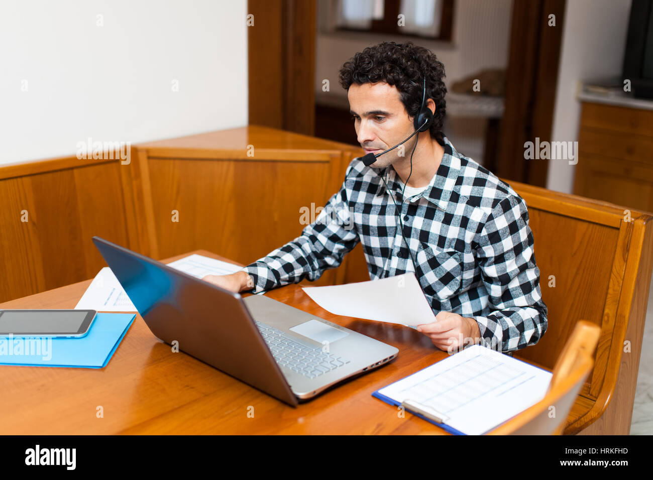 Guy using headset and laptop computer, chatting on Internet Stock Photo ...