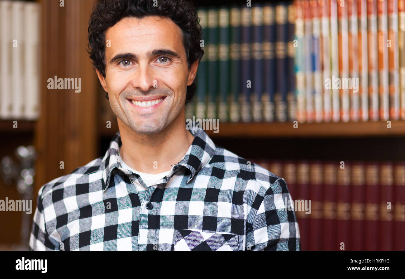 Smiling man in a library Stock Photo - Alamy