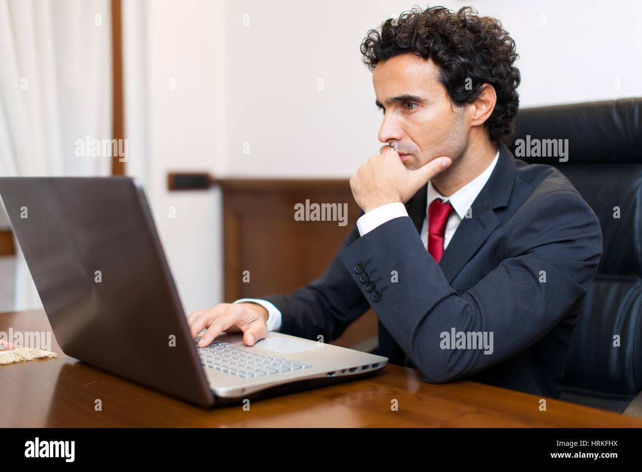 Businessman using a laptop in his office Stock Photo - Alamy