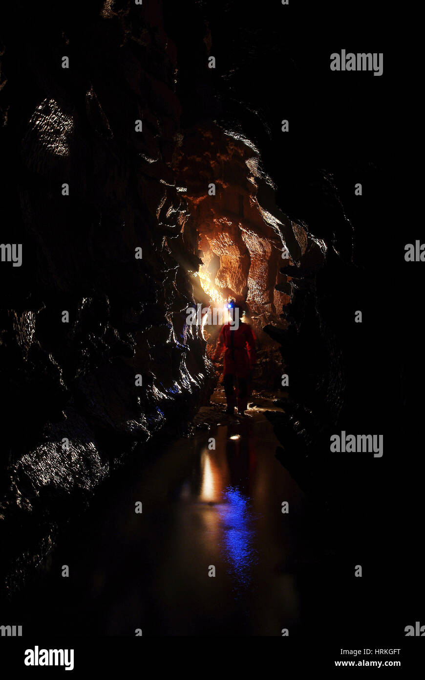 Spelunker exploring a cave Stock Photo - Alamy