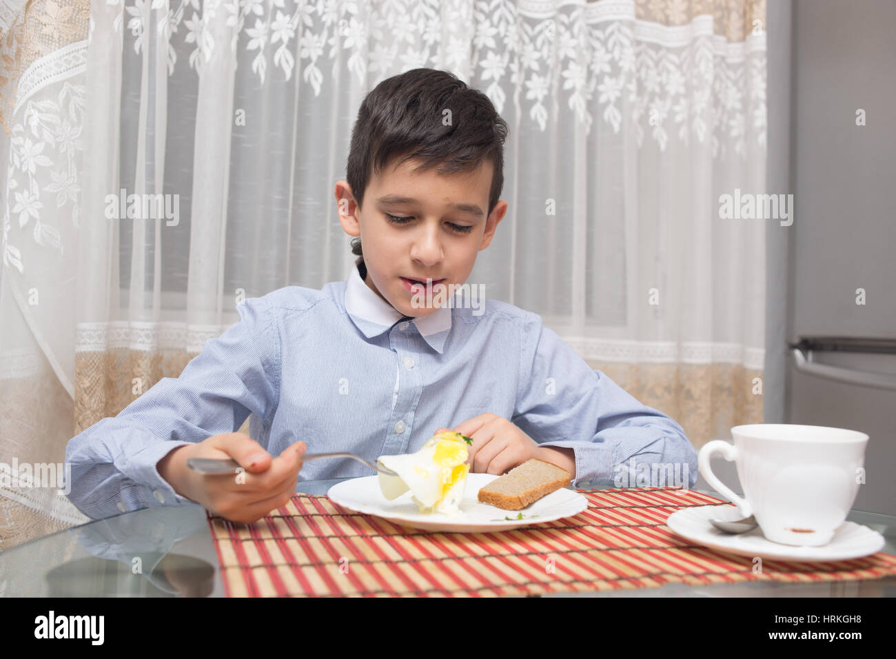 Boy teenager eating soup at the kitchen table Stock Photo - Alamy