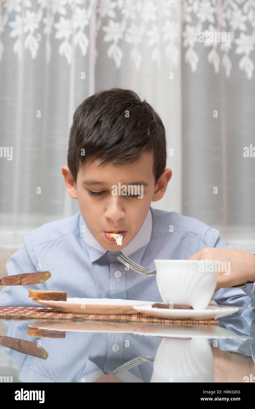 Boy teenager eating soup at the kitchen table Stock Photo - Alamy