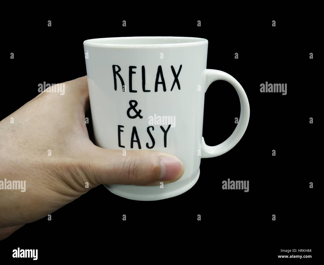 male hand holding a mug isolated on black background Stock Photo - Alamy