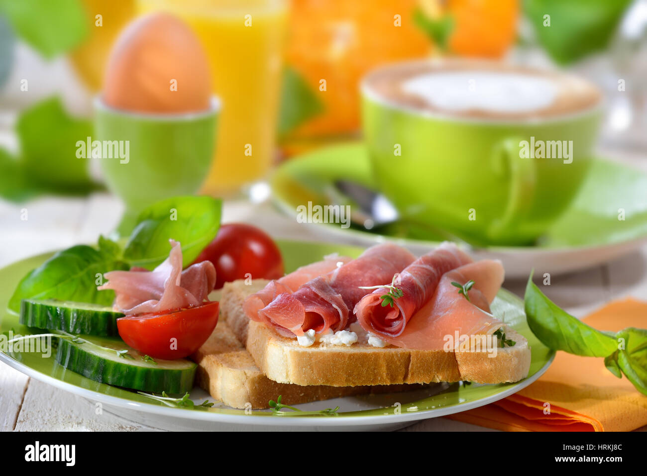 Breakfast with ham toast, a boiled egg, orange juice and a cup of ...