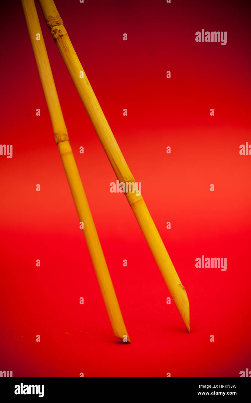 two sticks of bamboo on a red background Stock Photo - Alamy