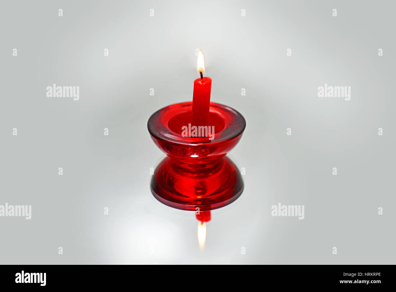 Red candle on mirror with reflection. Isolated on white background ...