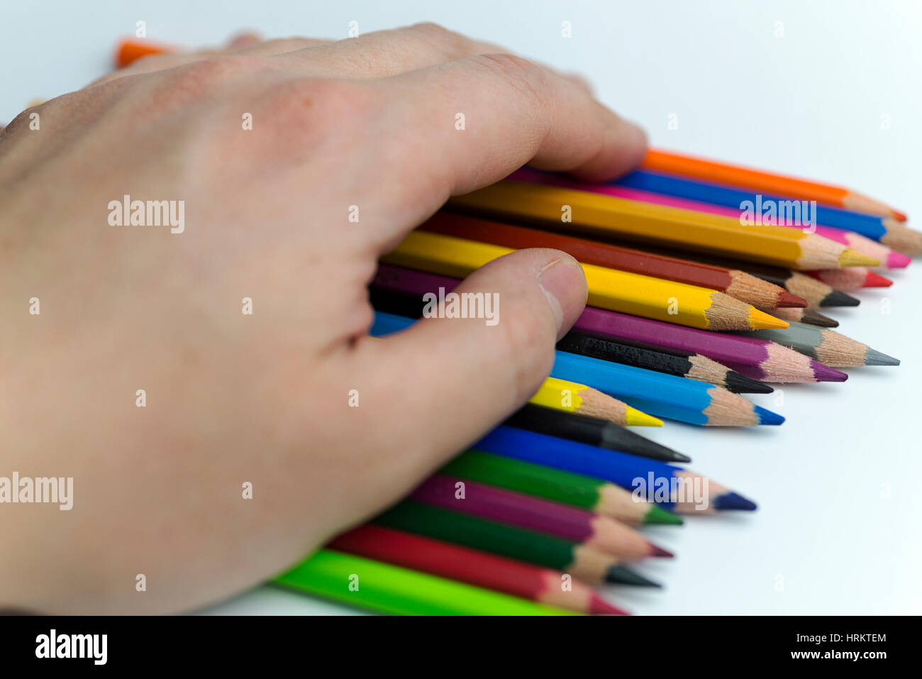 Hand holding colored pencils on white background Stock Photo - Alamy