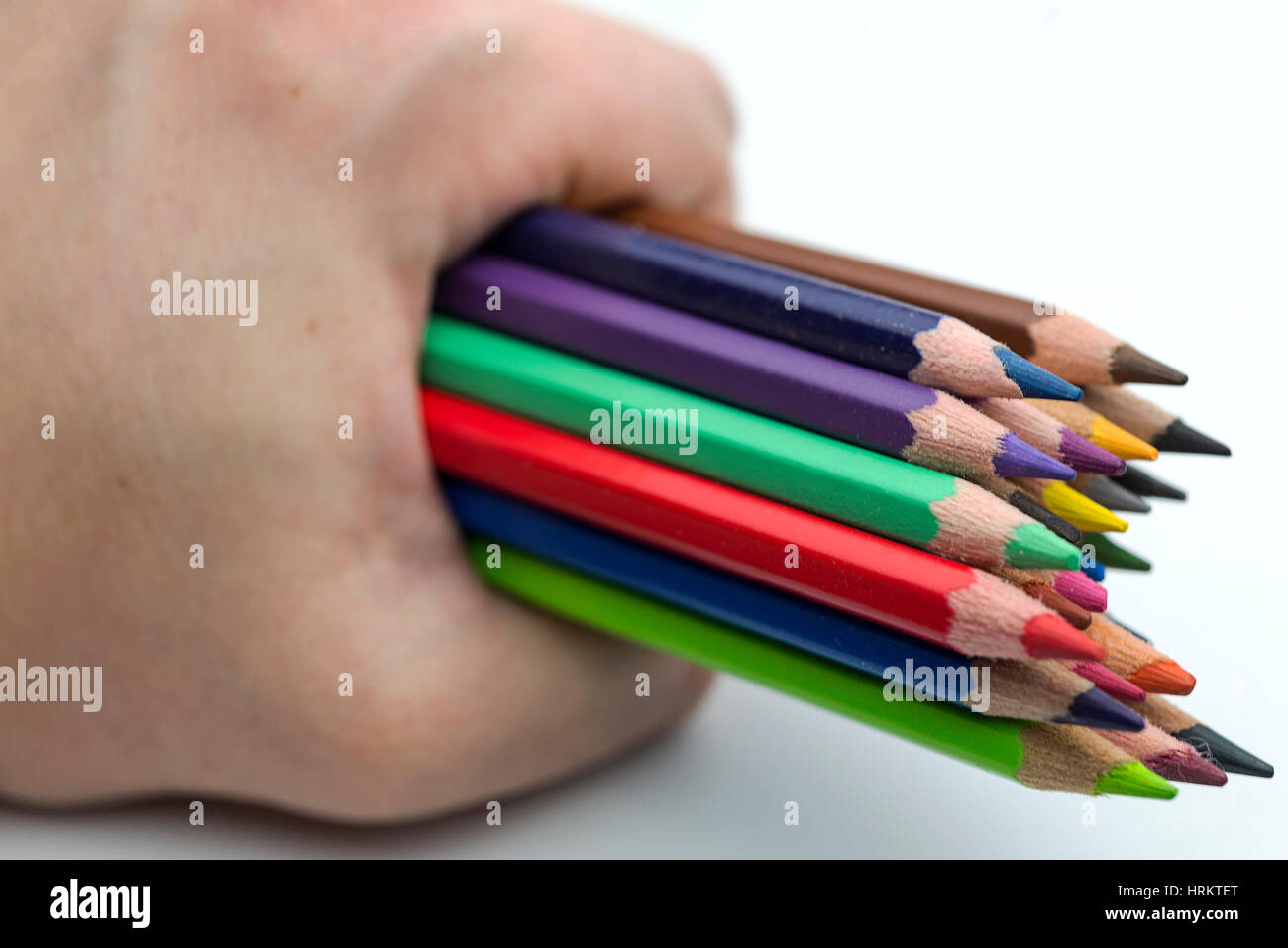 Hand holding colored pencils on white background Stock Photo - Alamy