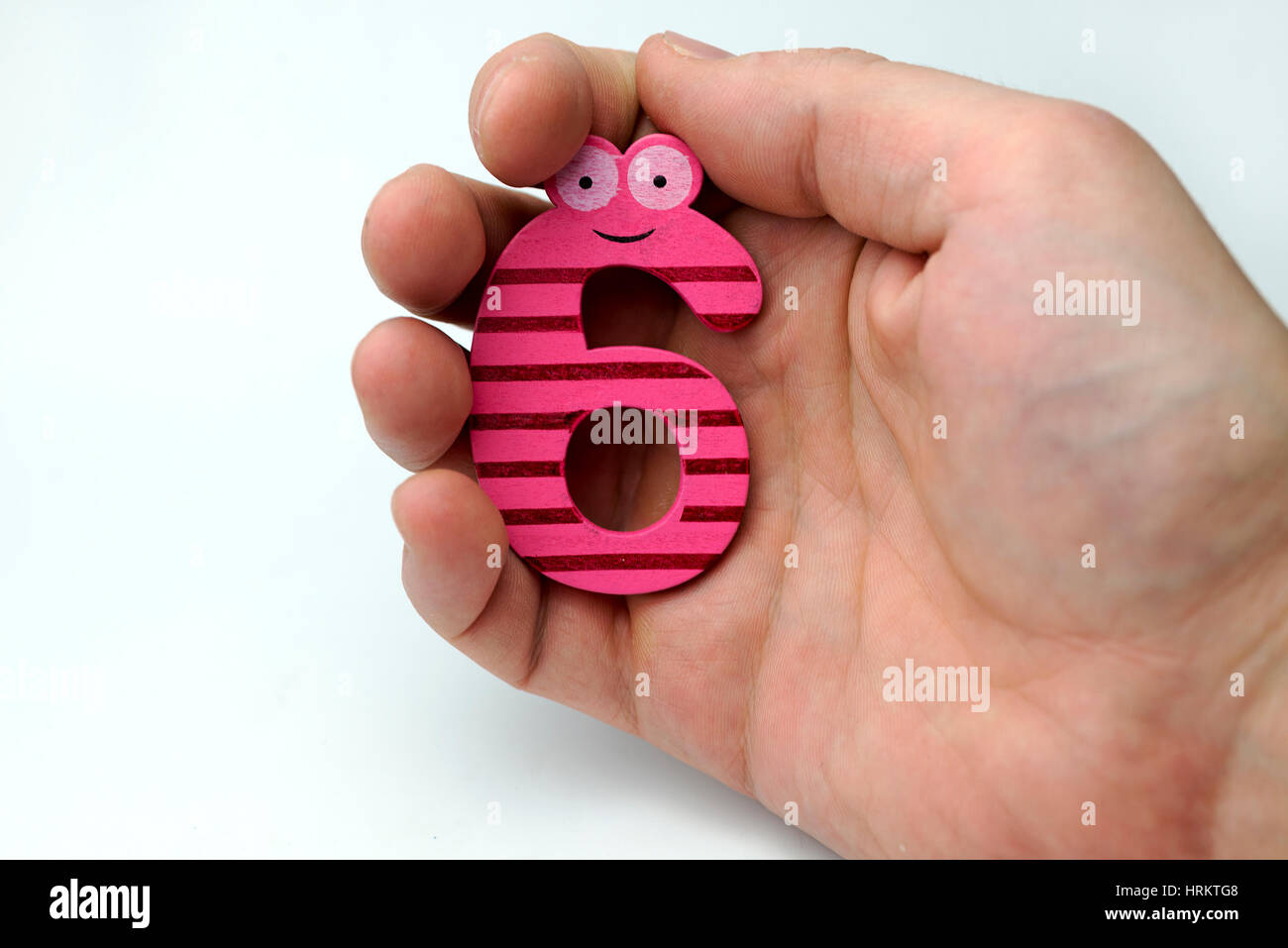 Hand holding number six on white background Stock Photo - Alamy
