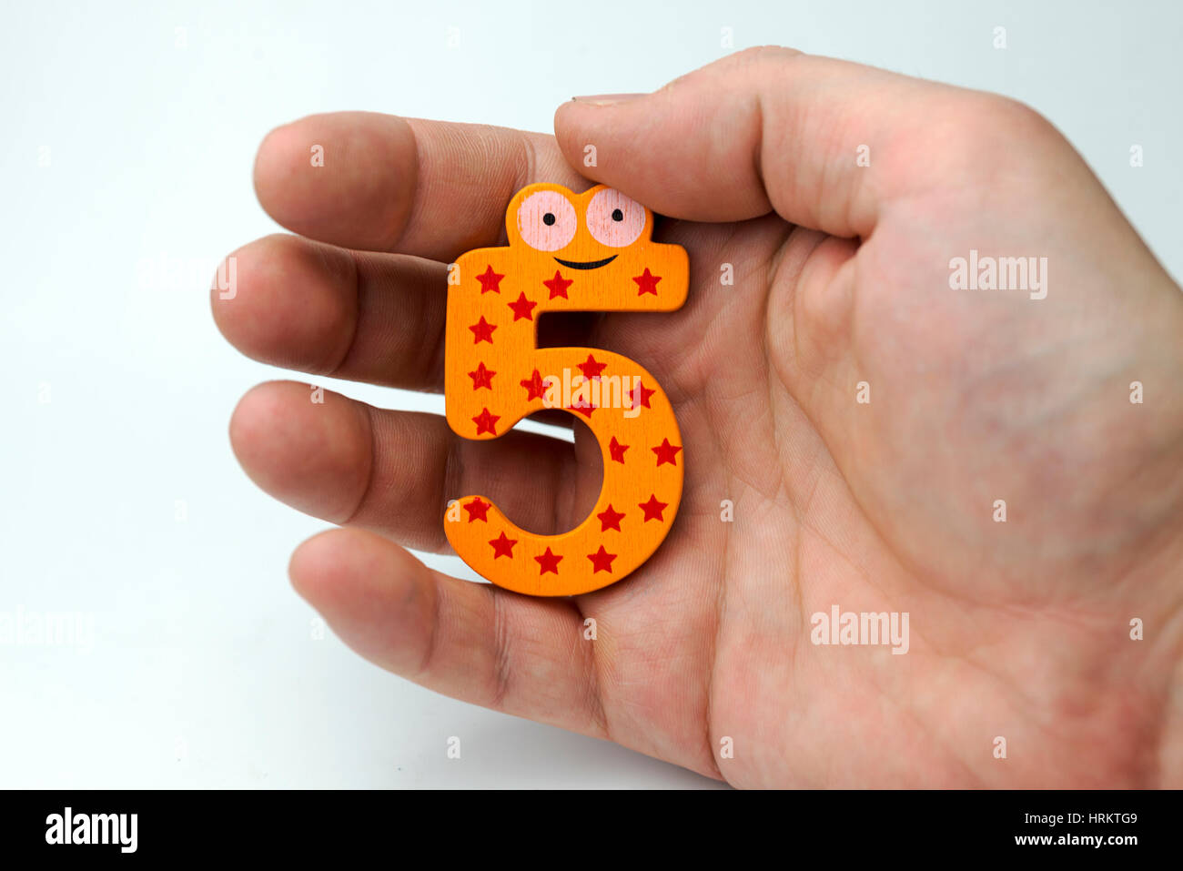 Hand holding number five on a white background Stock Photo - Alamy