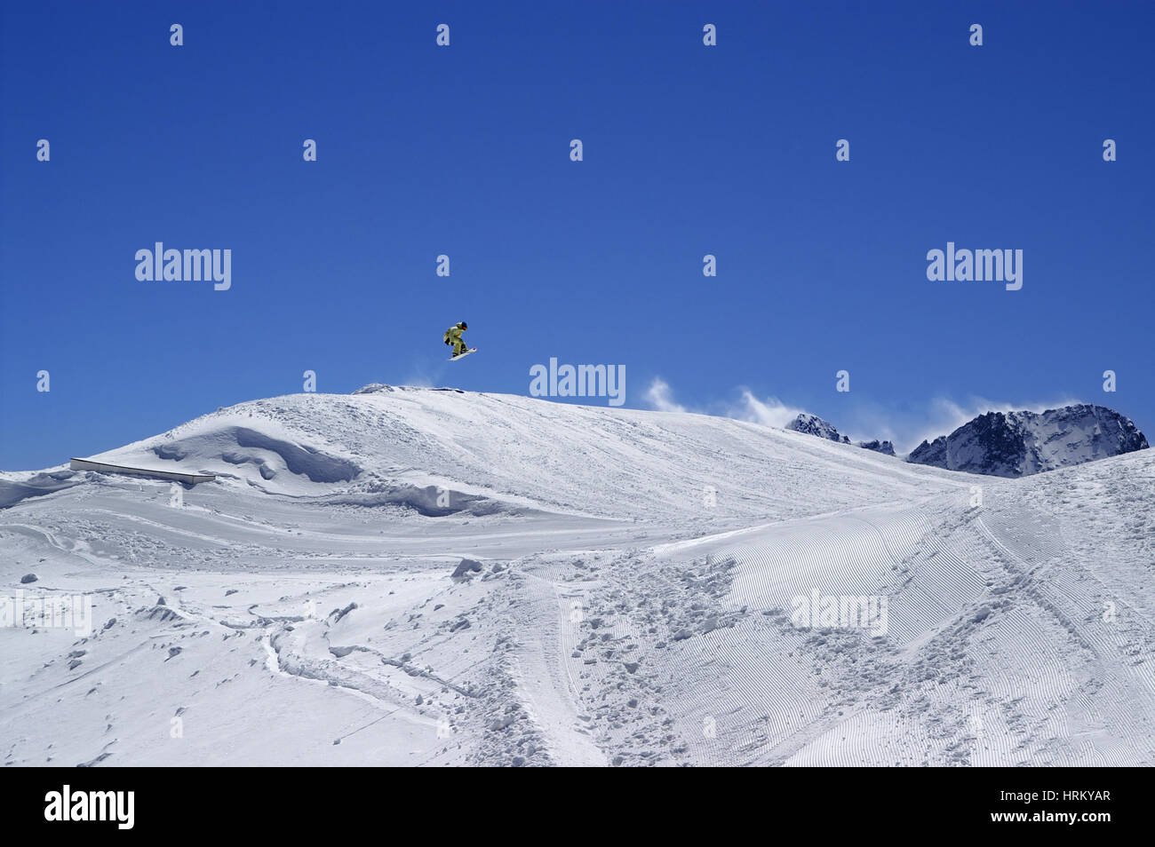 Snowboarder jumping in terrain park at ski resort on sun wind day ...