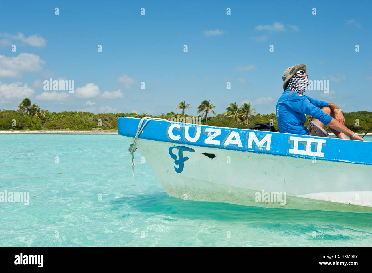 Tour guide relaxing on a boat in the crystal clear waters of Sian Kaan ...
