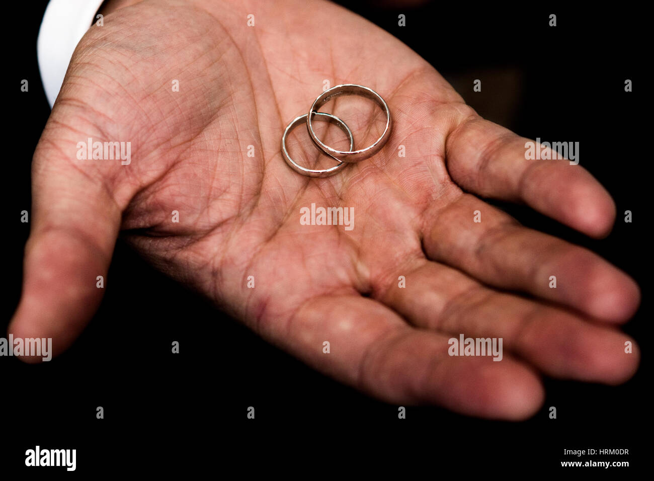 Wedding rings held by the groom Stock Photo - Alamy