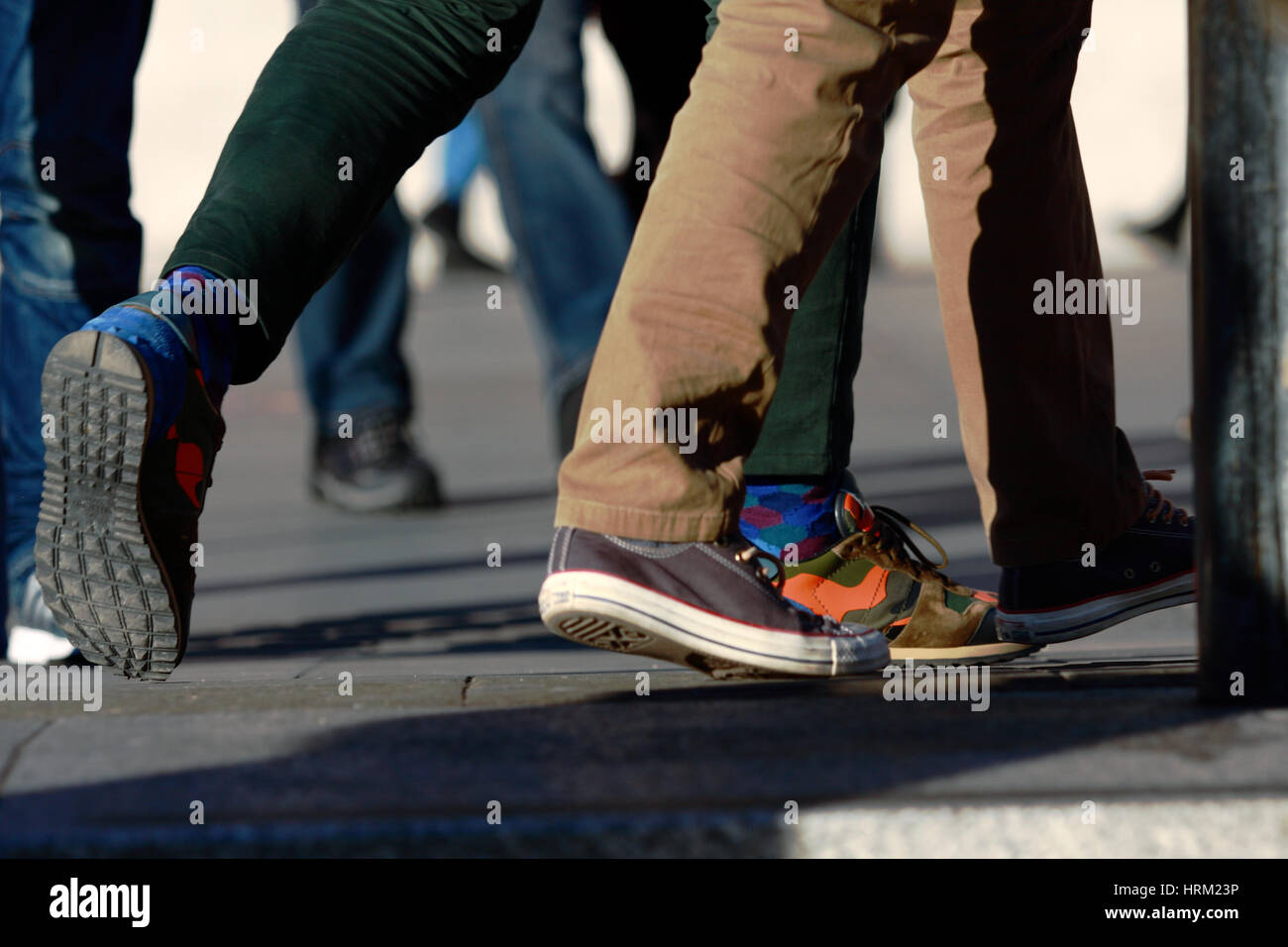 A ground level view of peoples legs walking and standing in Trafalgar ...