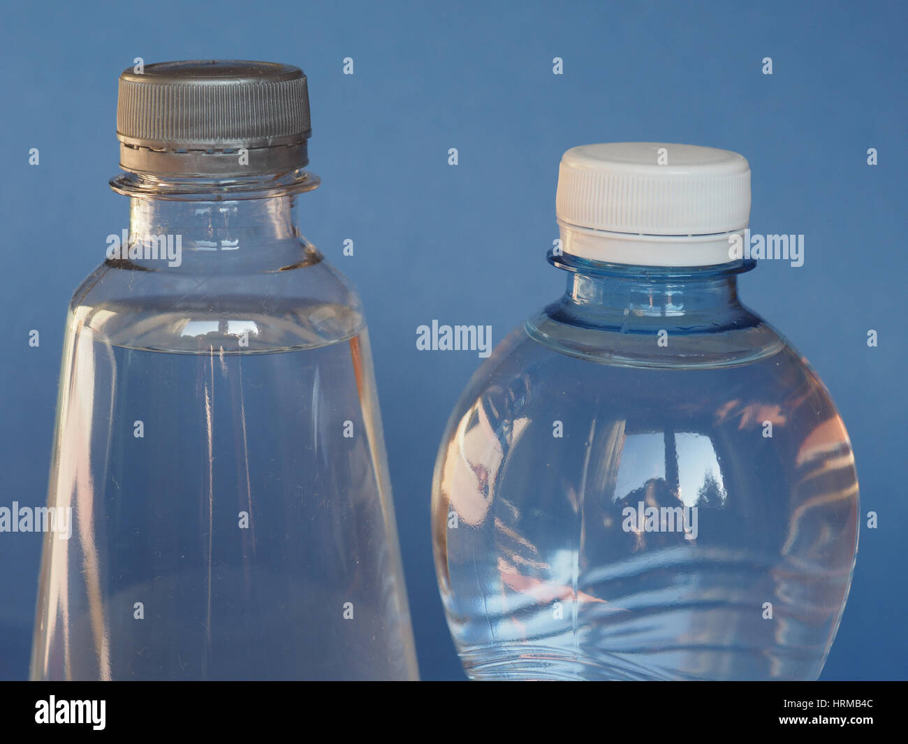 two bottles of water over blue background Stock Photo - Alamy