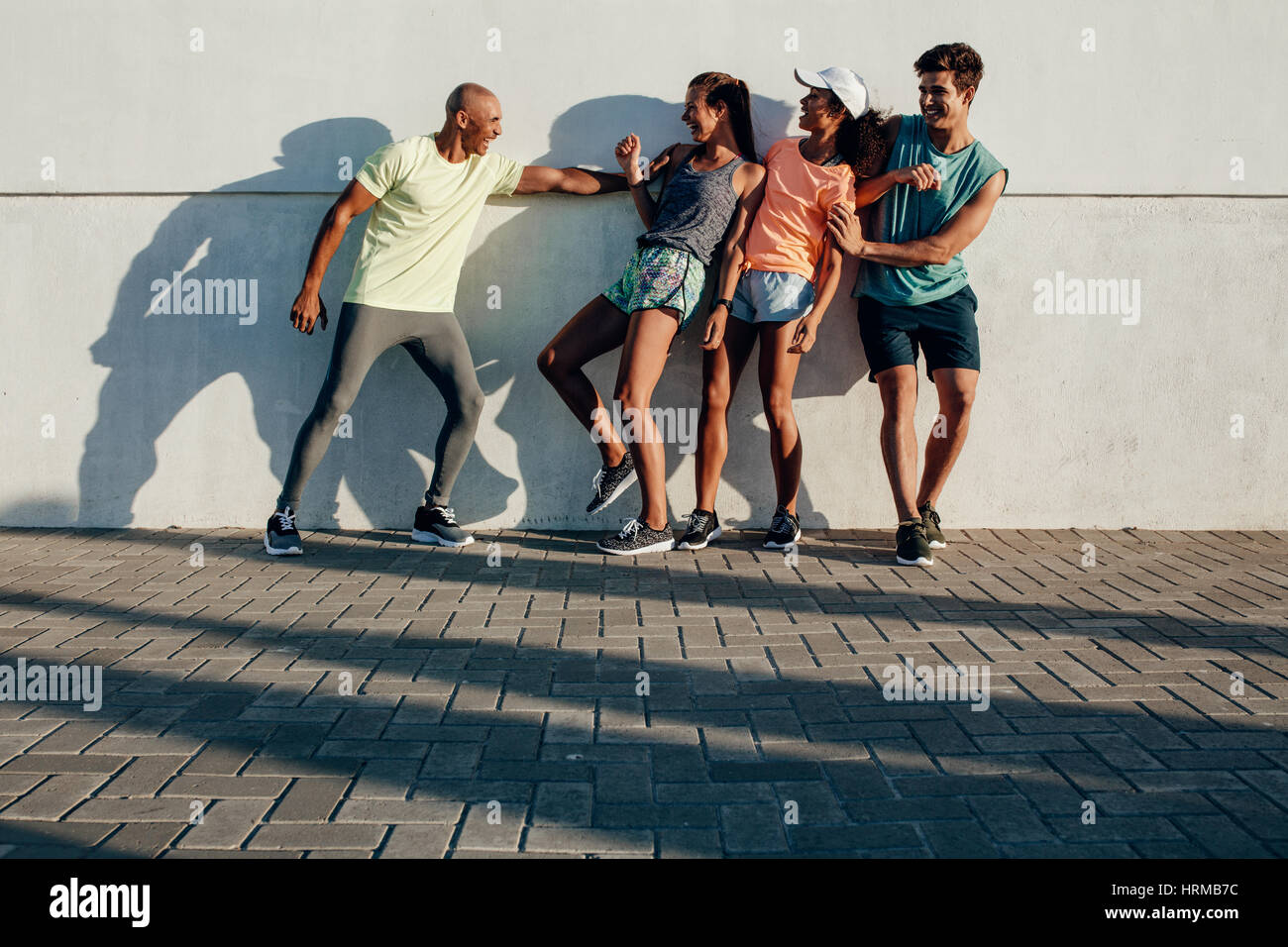 Full length shot of happy young people having fun together by a wall ...