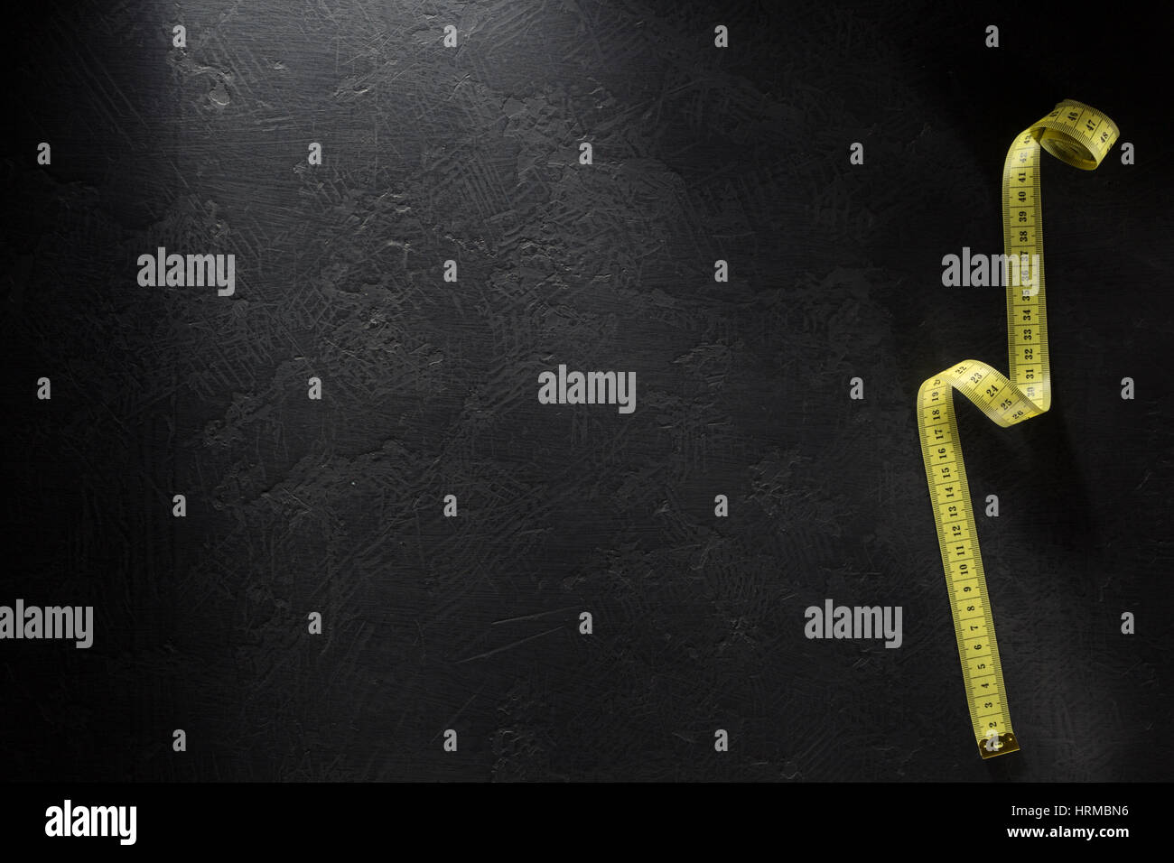 tape measuring on black background texture Stock Photo - Alamy