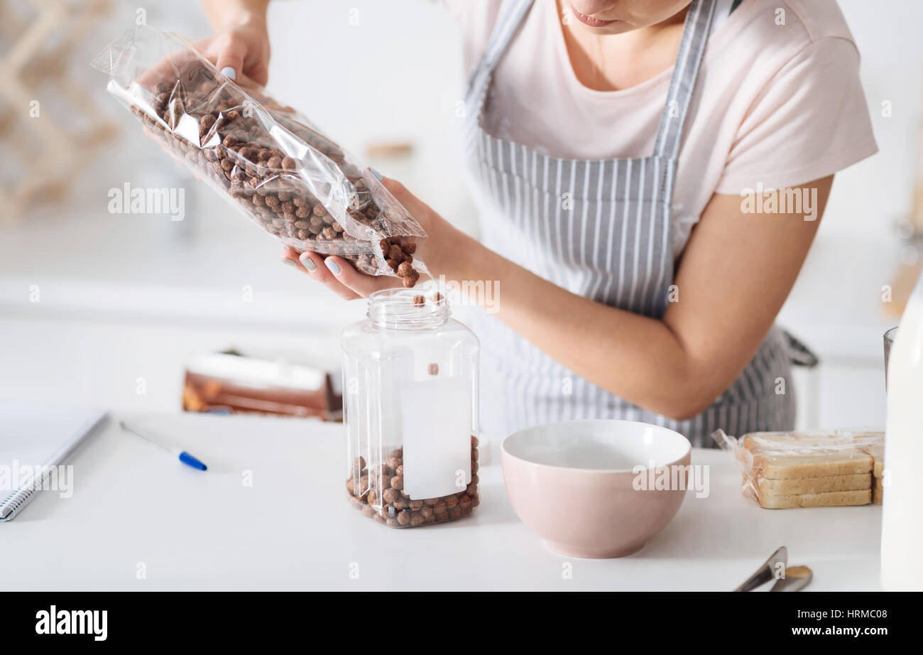 Careful woman filling up a jar Stock Photo - Alamy