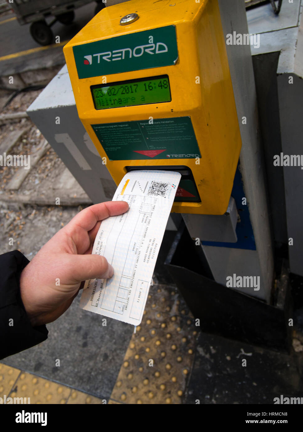 Commuter validating a train ticket Stock Photo - Alamy