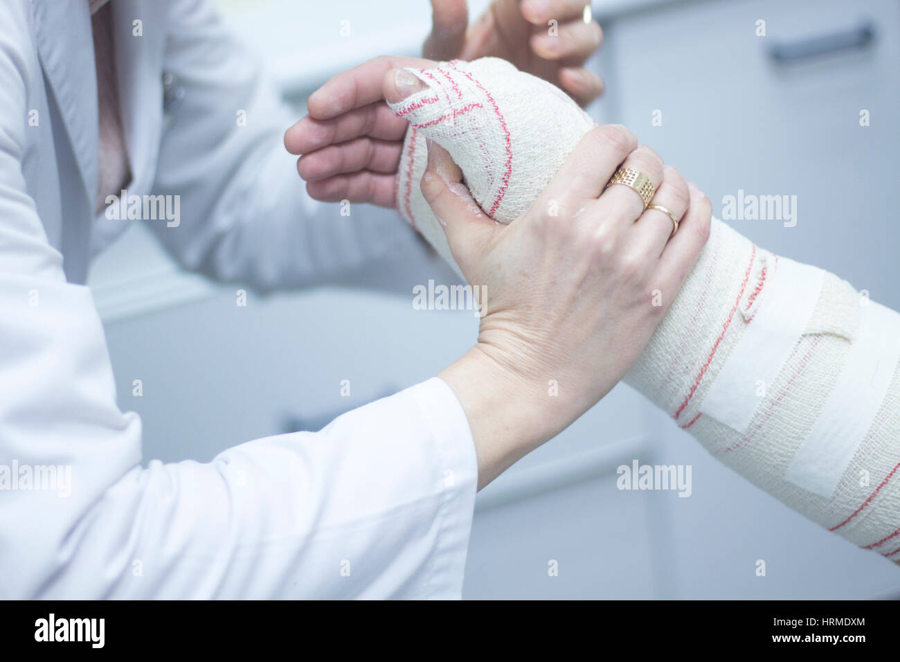Doctor applying a plaster cast and bandages to patient forearm and ...