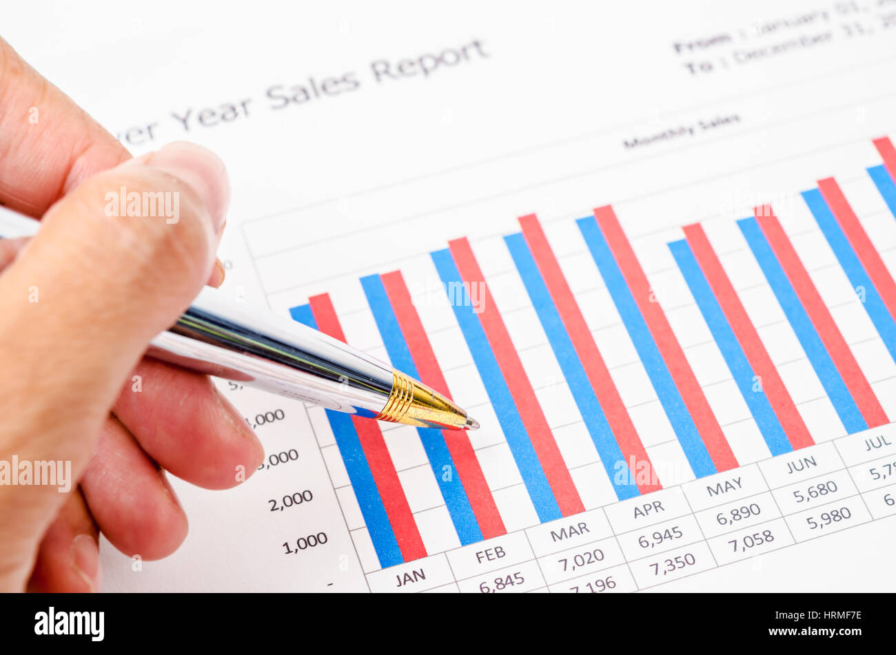 Hand holding pen on business report document Stock Photo - Alamy