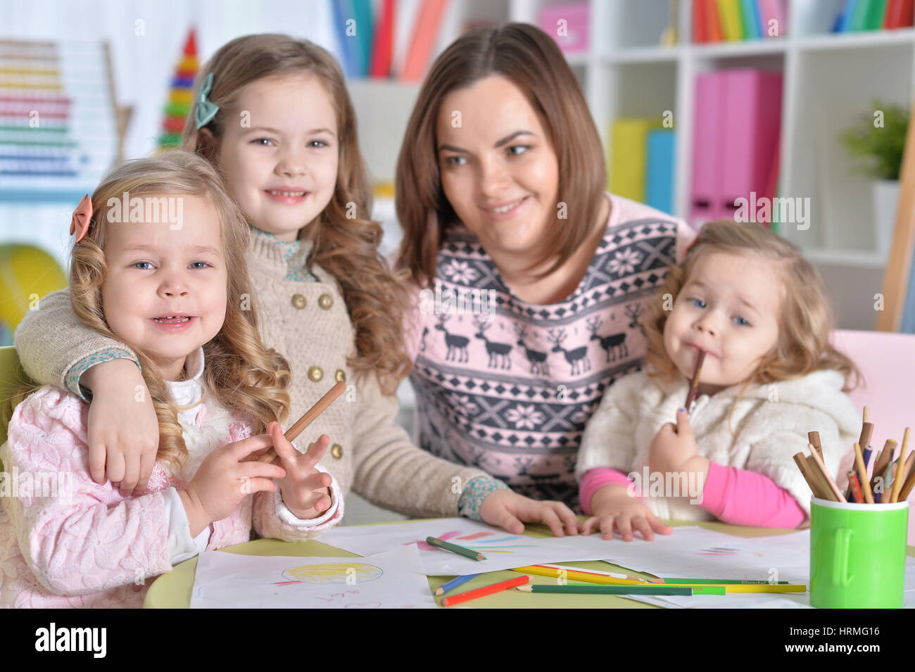 Mother and her three daughters drawing together Stock Photo - Alamy