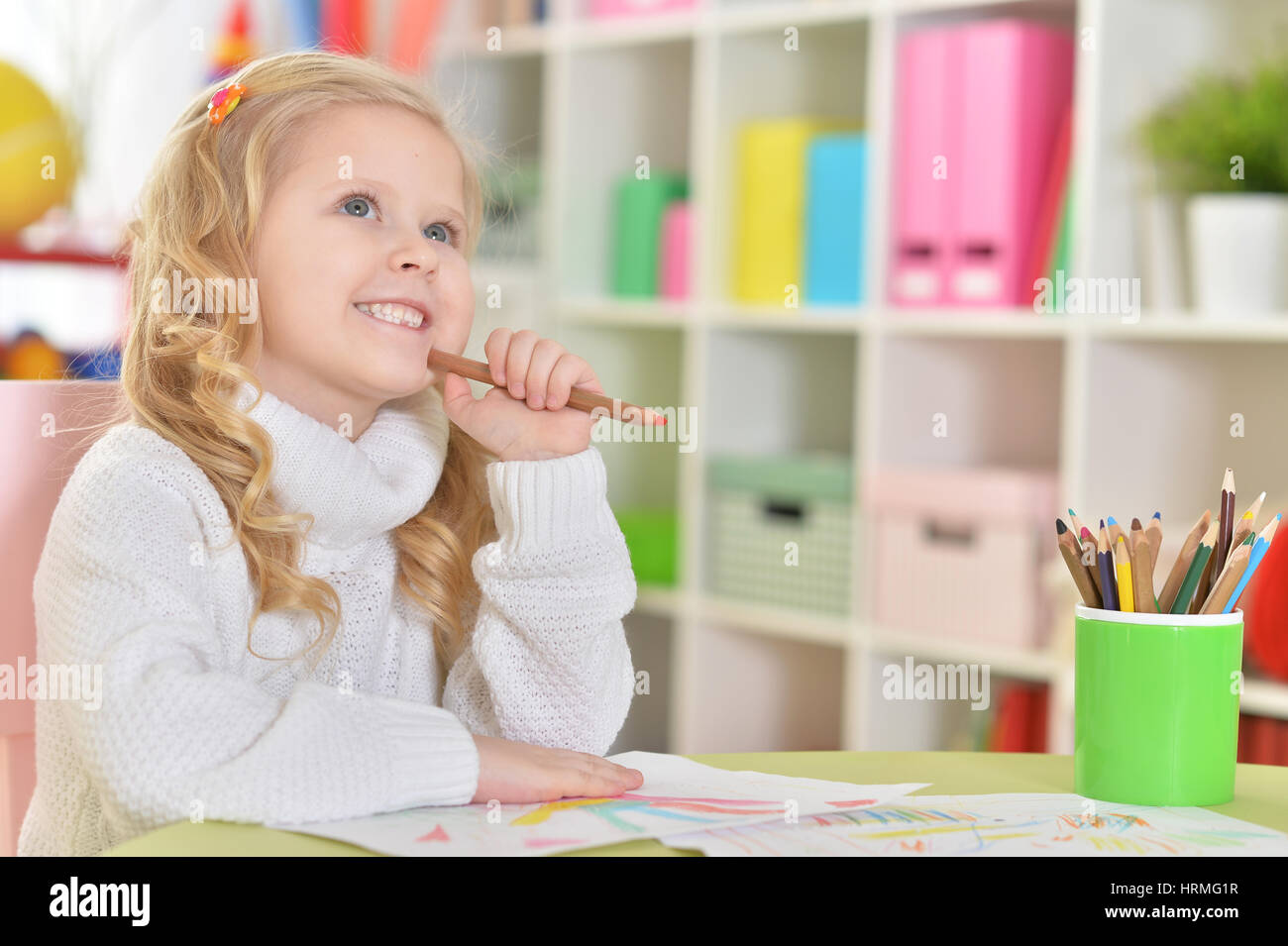Portrait of a cute little girl drawing and dreaming Stock Photo - Alamy
