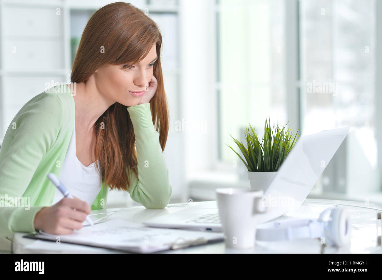 Young beautiful girl working at a laptop Stock Photo - Alamy