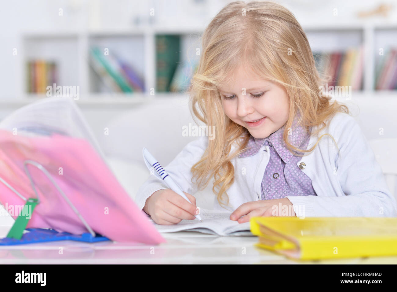 Portrait of a cute little girl doing her homework Stock Photo - Alamy