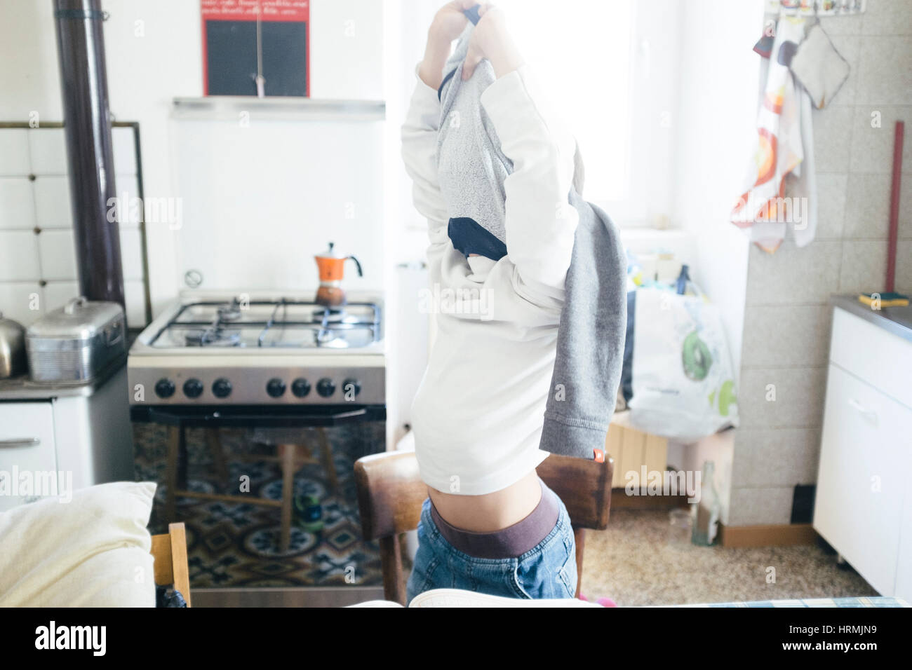 child takes off sweater at home Stock Photo - Alamy