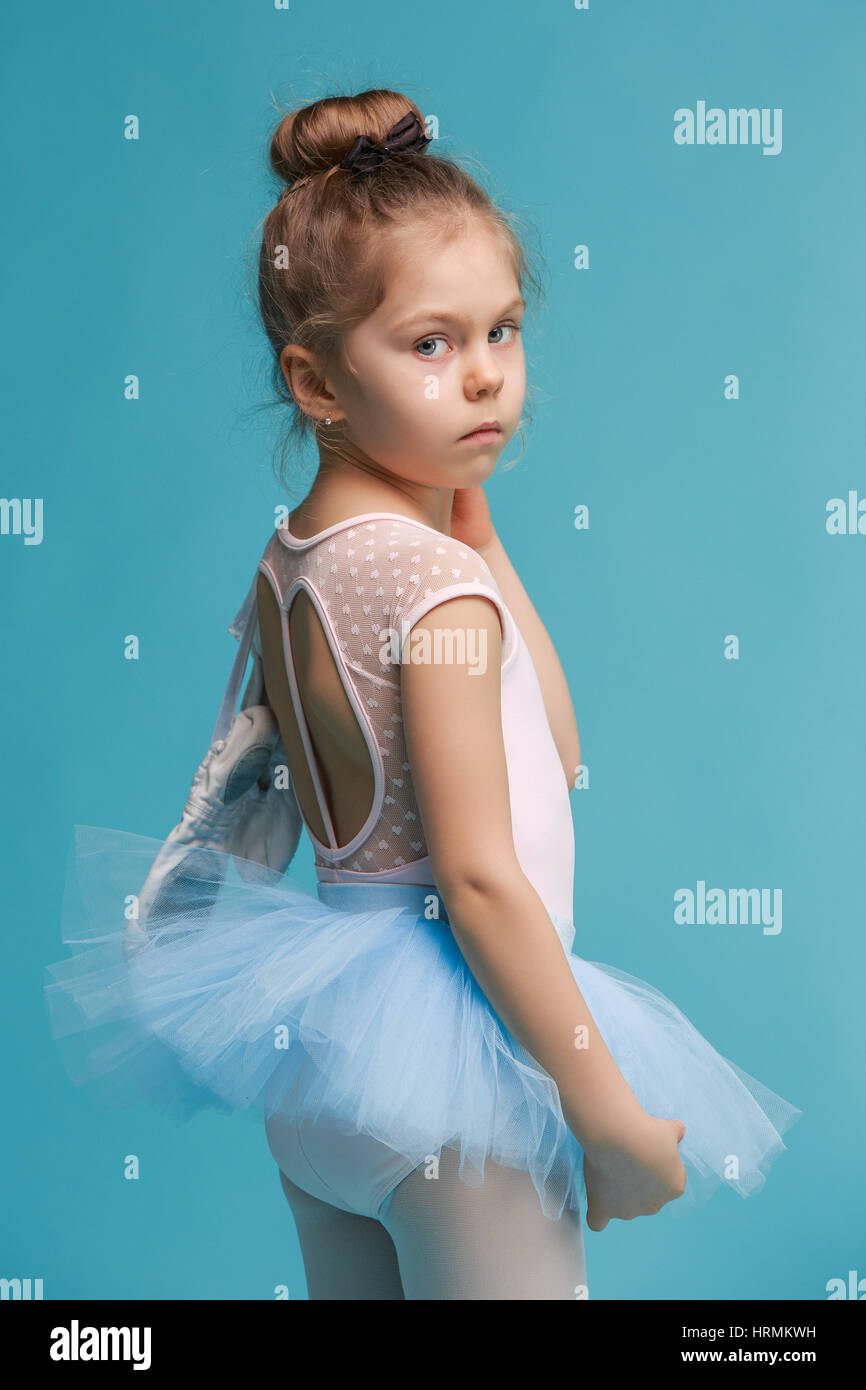 The little girl as balerina dancer standing with ballet shoes on blue ...