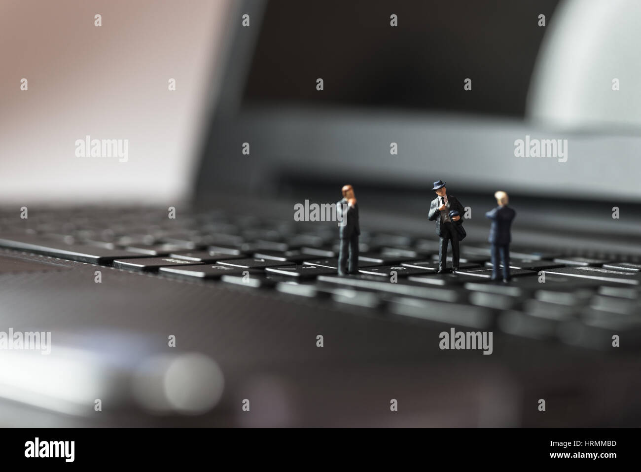 Miniature business people standing on laptop keyboard Stock Photo - Alamy