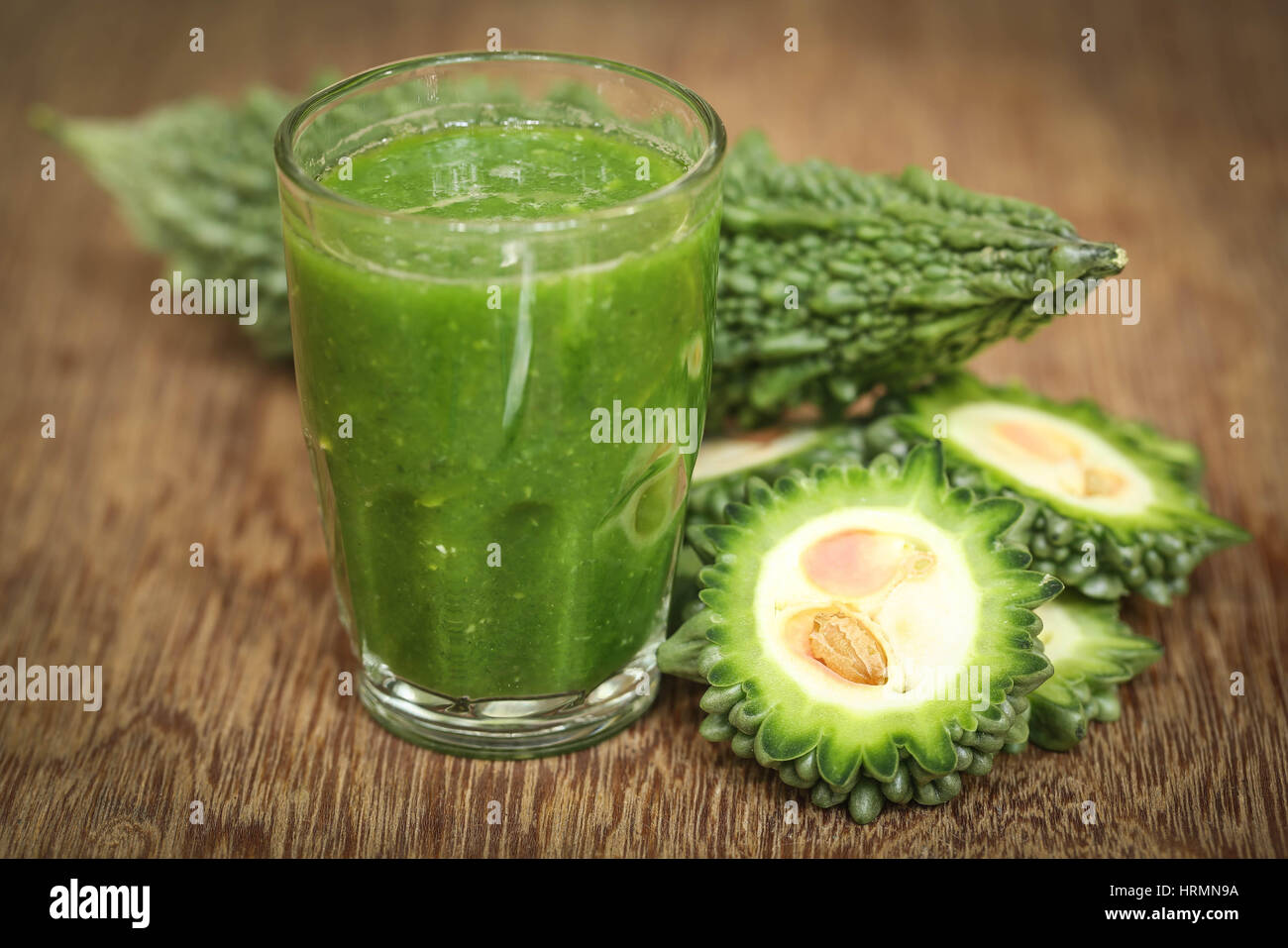 Herbal juice of green momodica in a glass on timber surface Stock Photo ...