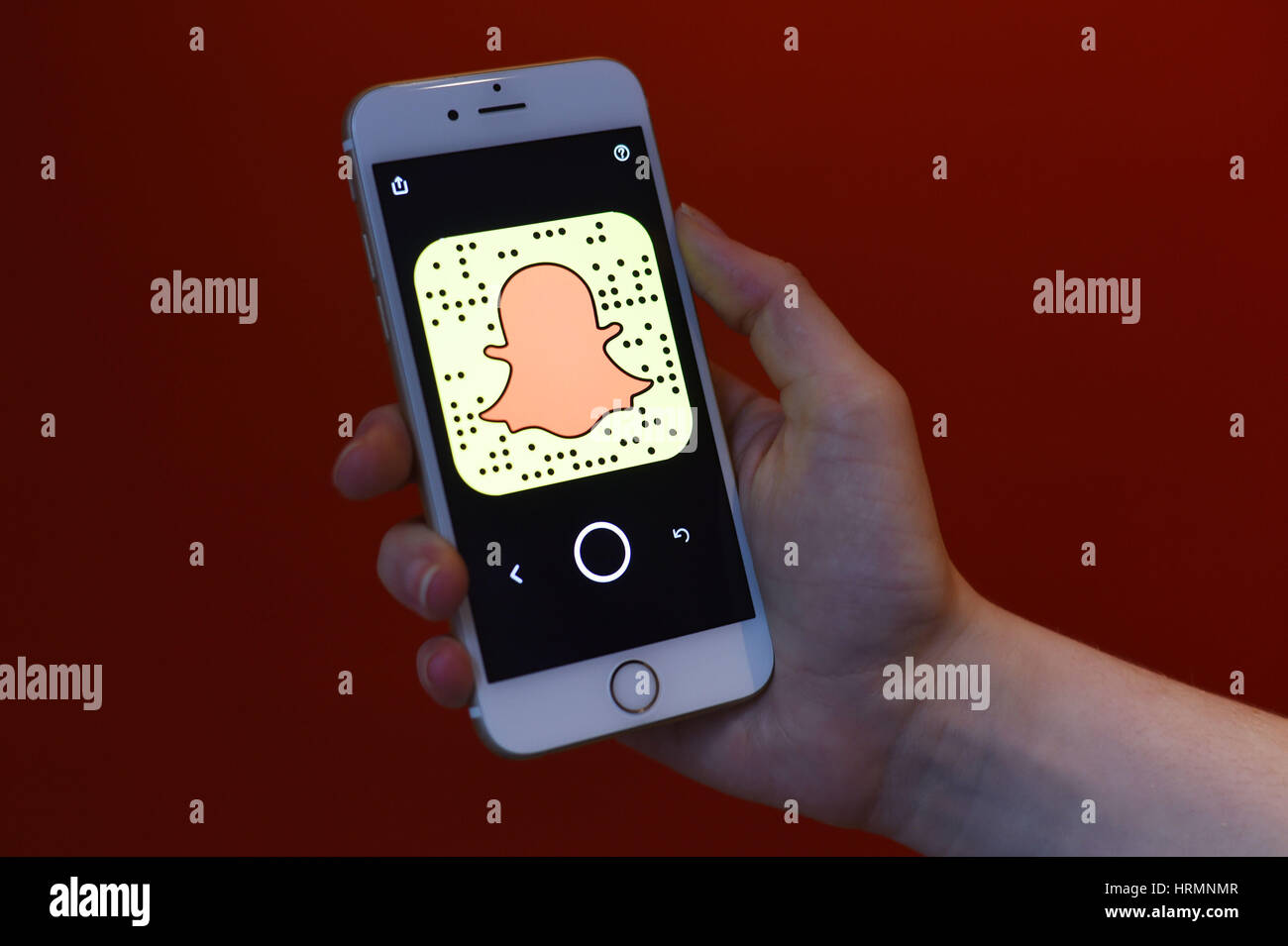 A general view of a woman holding a mobile phone with the Snapchat app ...