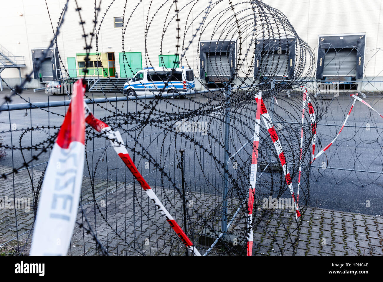 A fence topped with razor wire around a former refugee shelter in ...