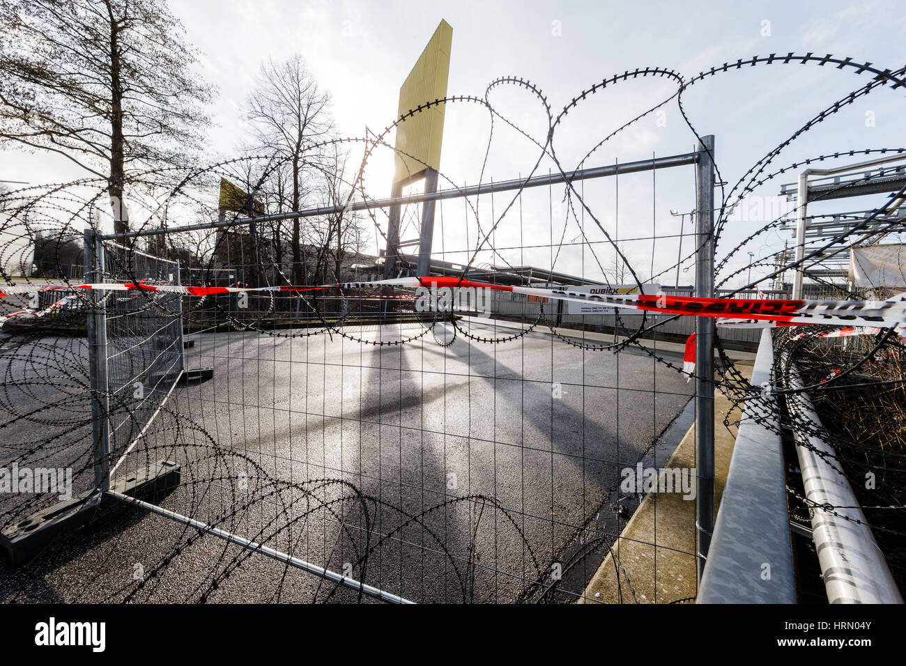 A fence topped with razor wire around a former refugee shelter in ...