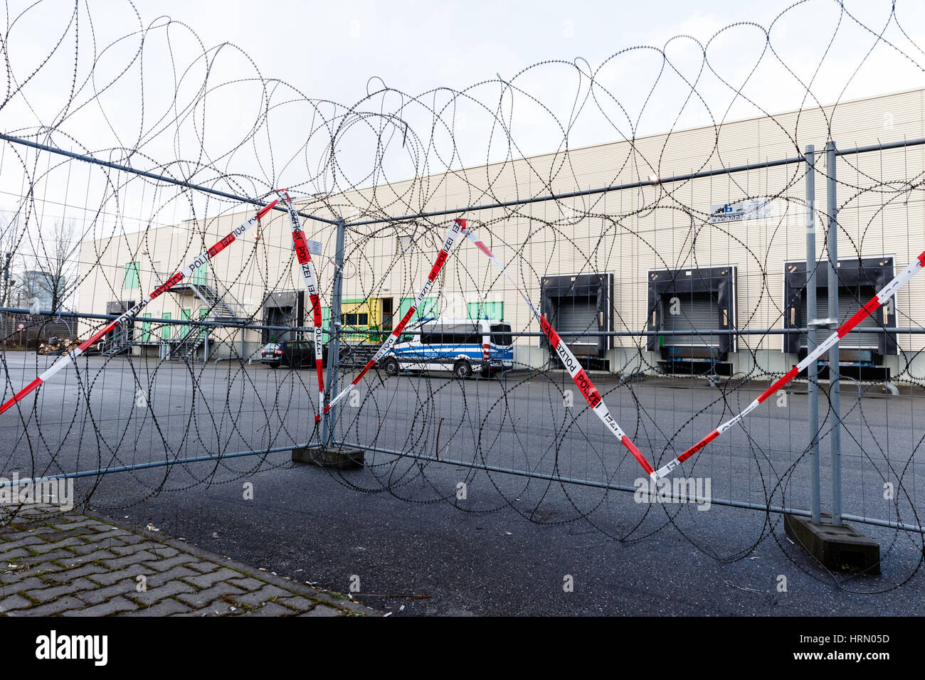 A fence topped with razor wire around a former refugee shelter in ...
