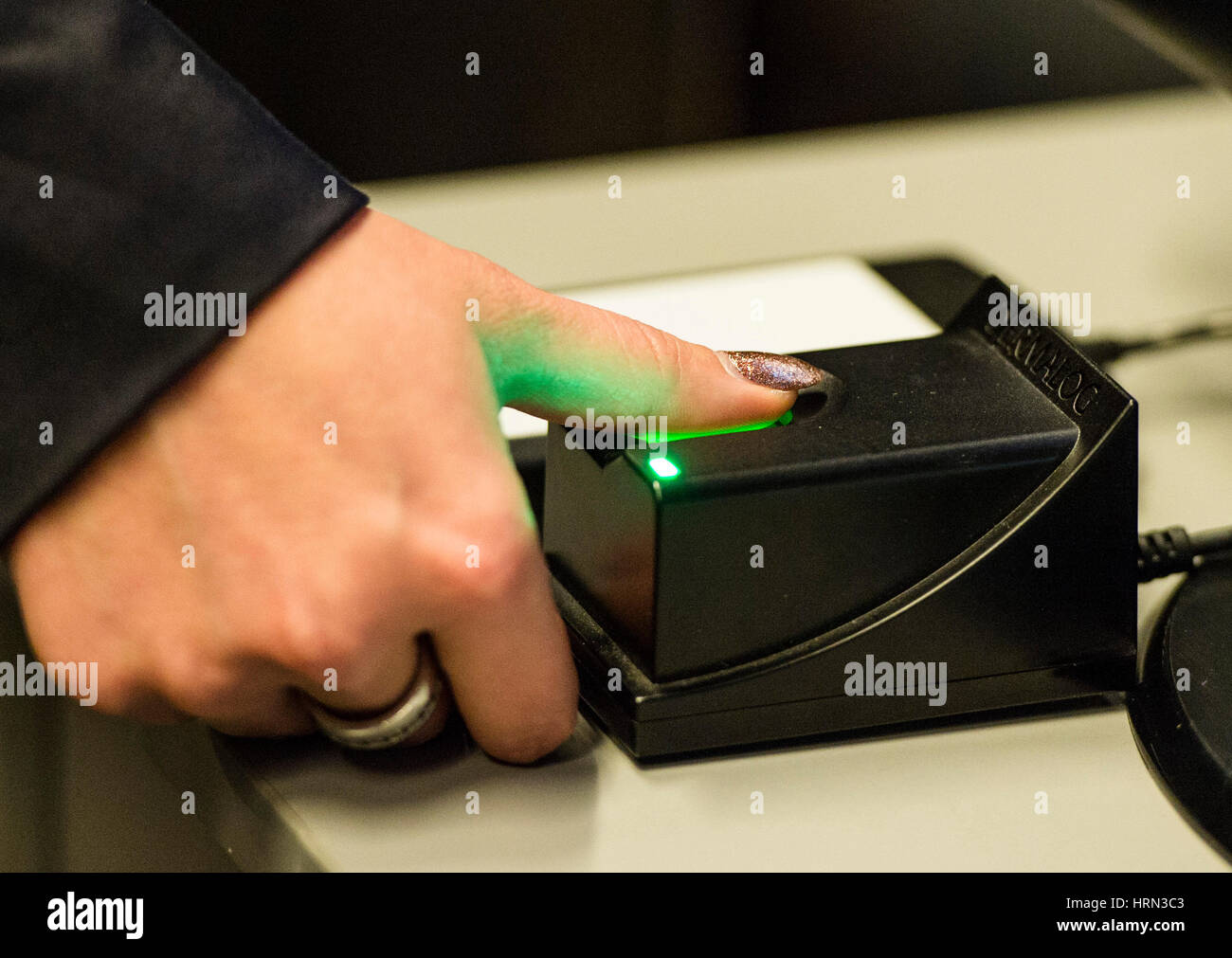 A woman demonstrates the usage of a fingerprint scanner during a press ...